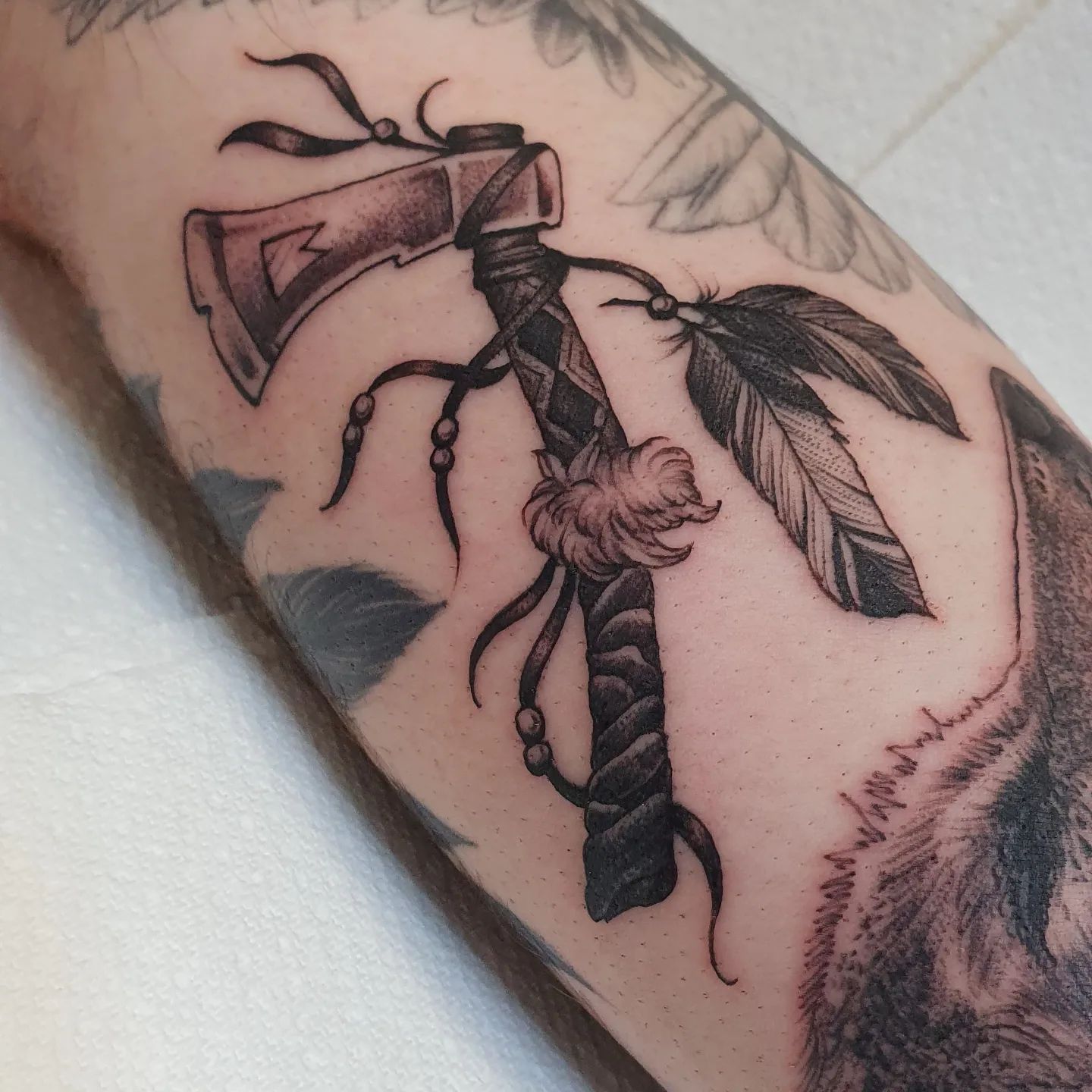 Feather and Axe Forearm Tattoo • Tattoodo