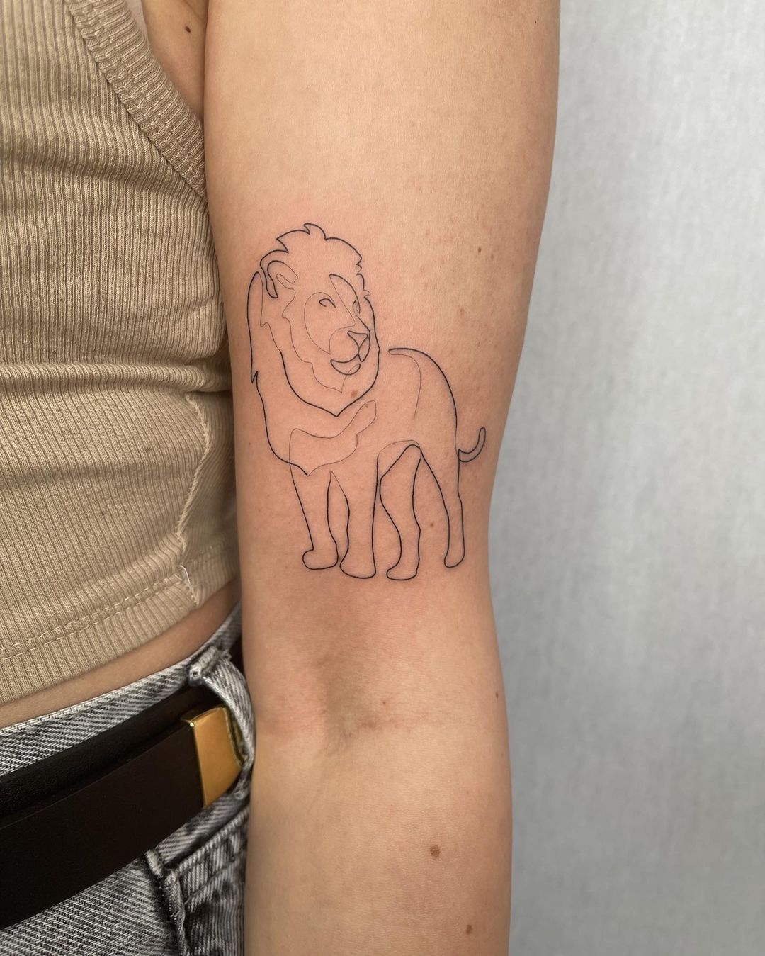 Fine Line Lion on Upper Arm • Tattoodo