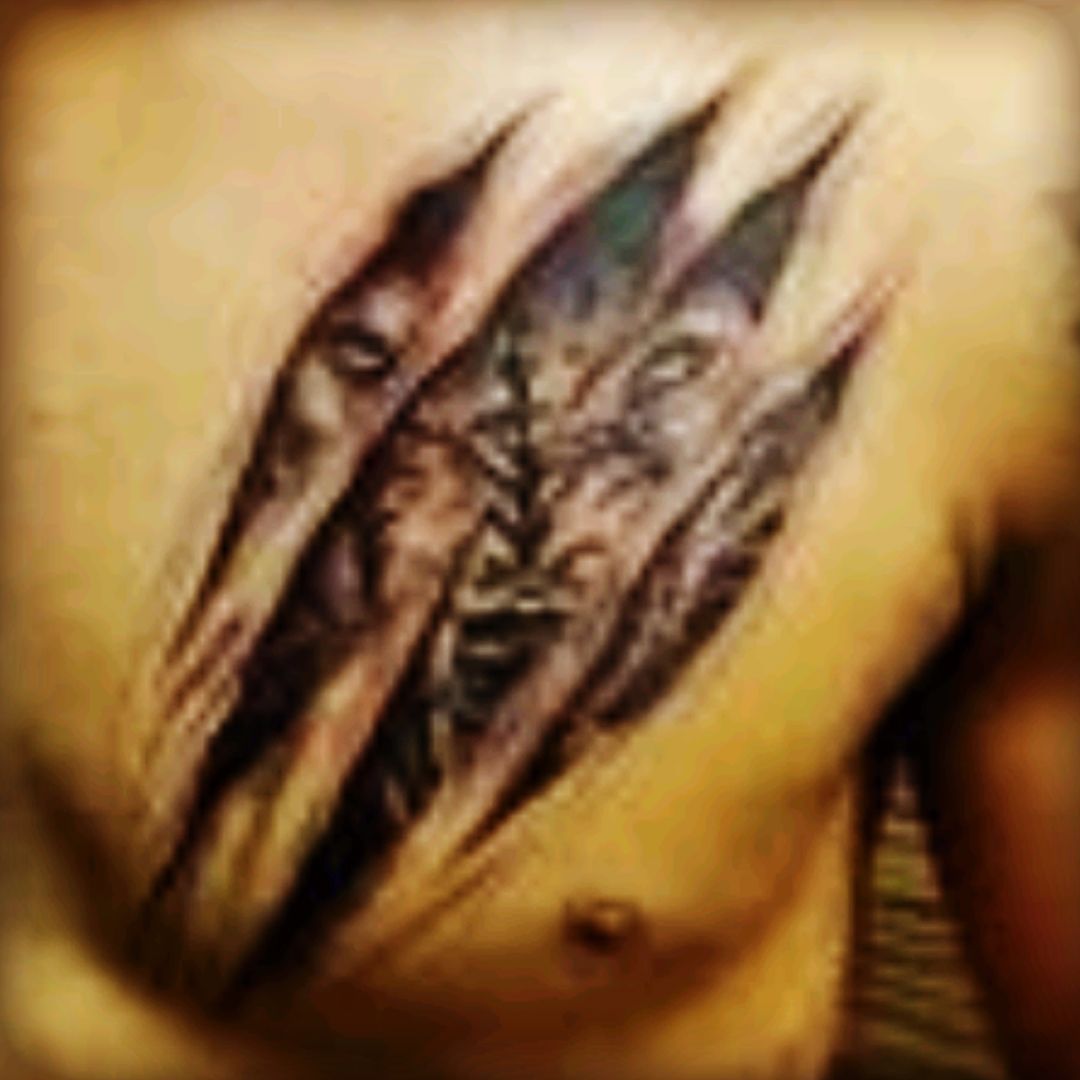 Wolf ripping through skin tattoo - Bronctattooaus.com